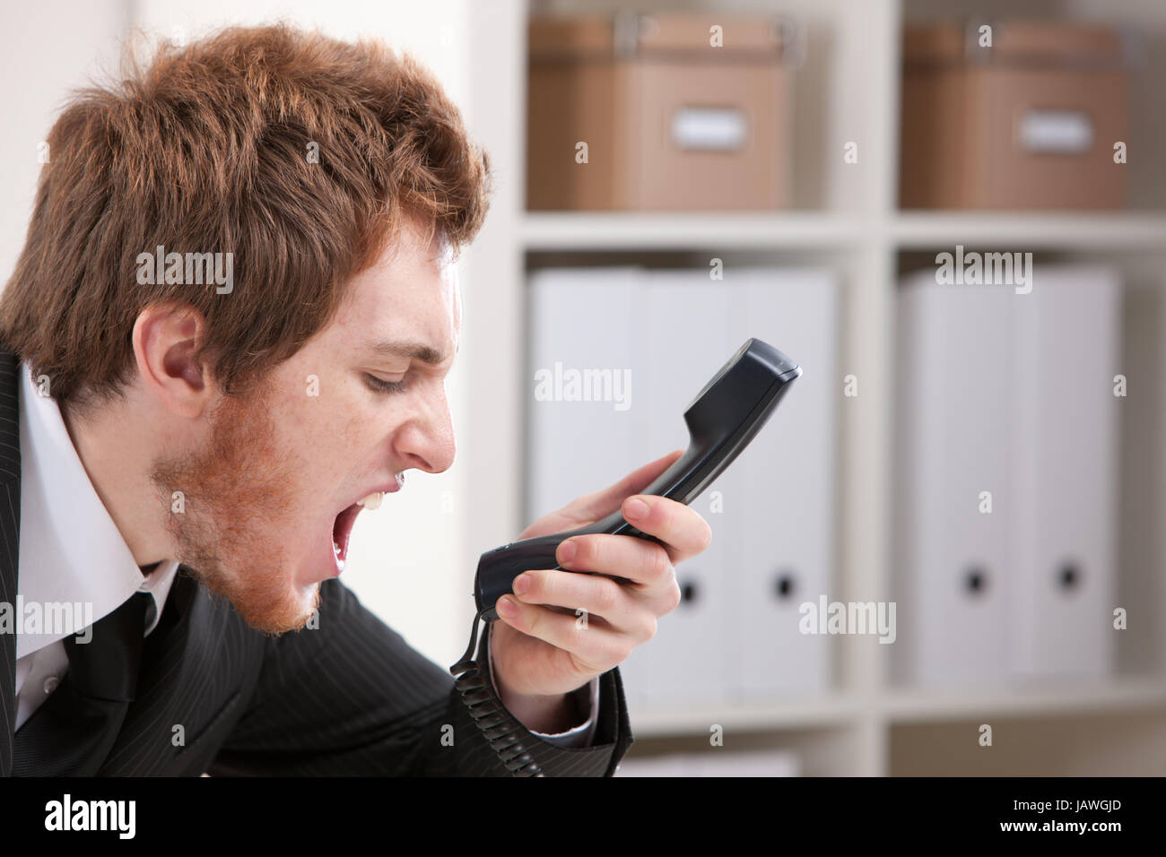 Young redheaded businessman shouting at his phone headset Stock Photo ...