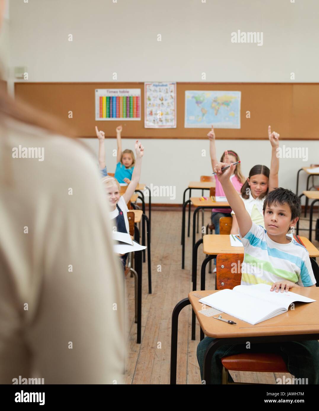 Students with hands raised in class Stock Photo - Alamy