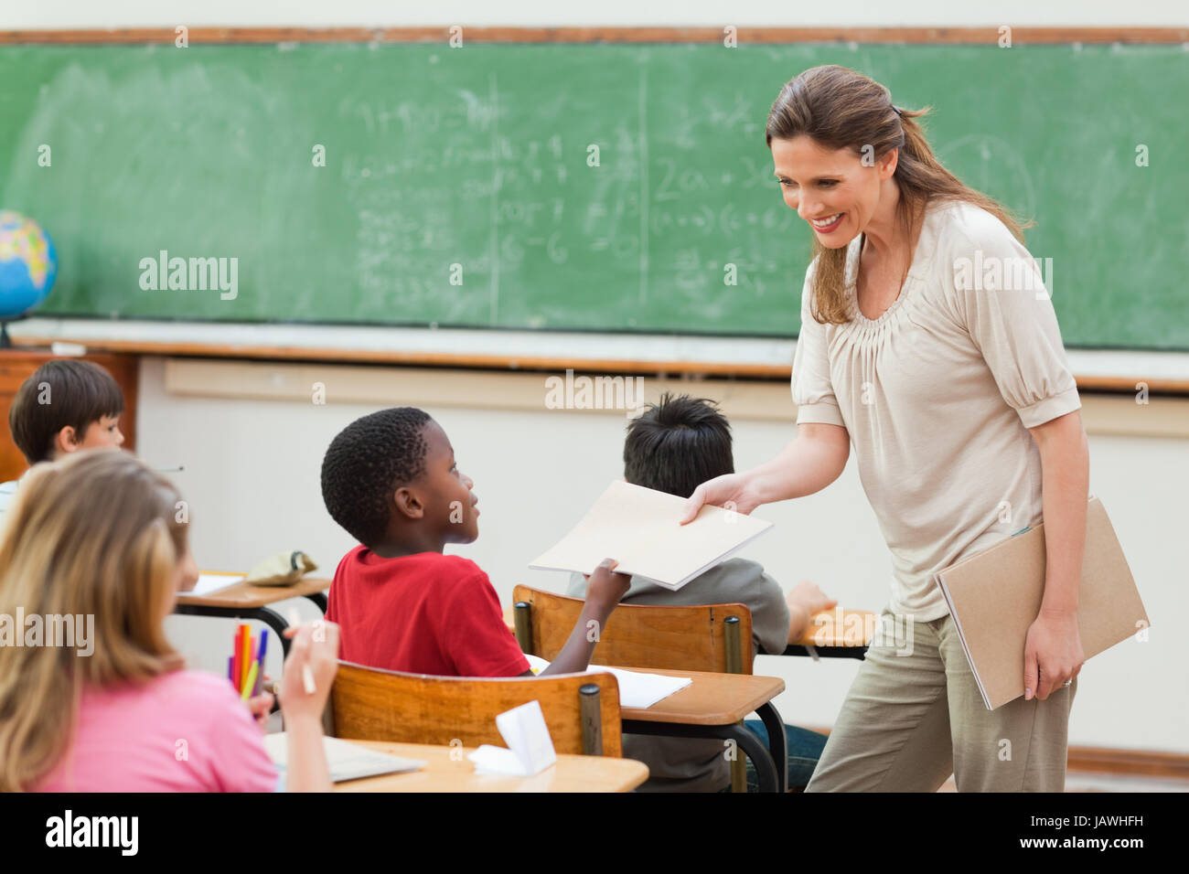 Teacher collecting her students exercise books Stock Photo - Alamy
