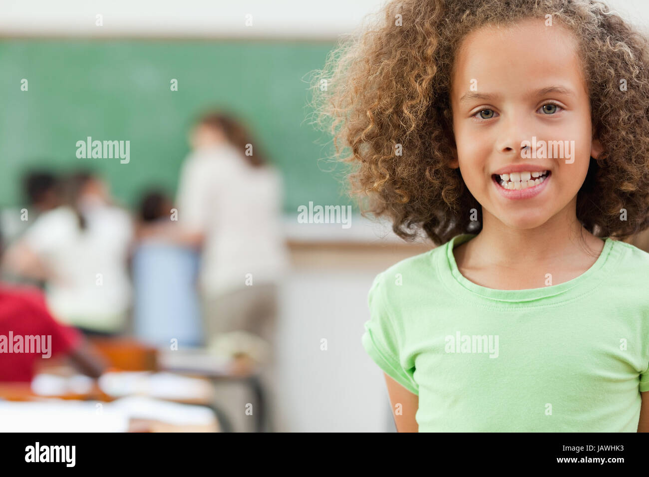 Smiling girl standing in the classroom Stock Photo - Alamy
