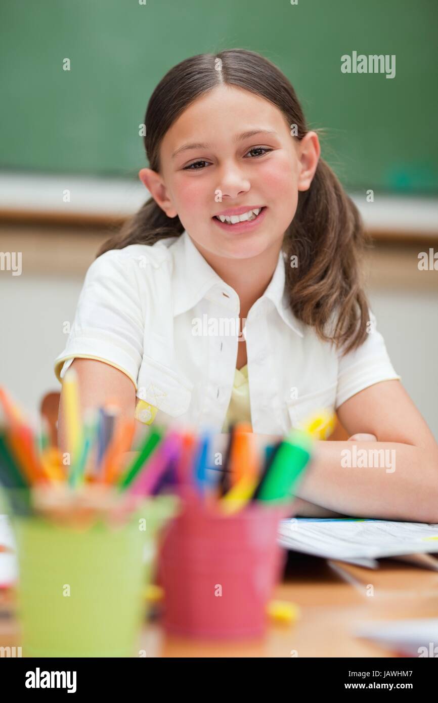 Smiling student next to pencil holders Stock Photo - Alamy