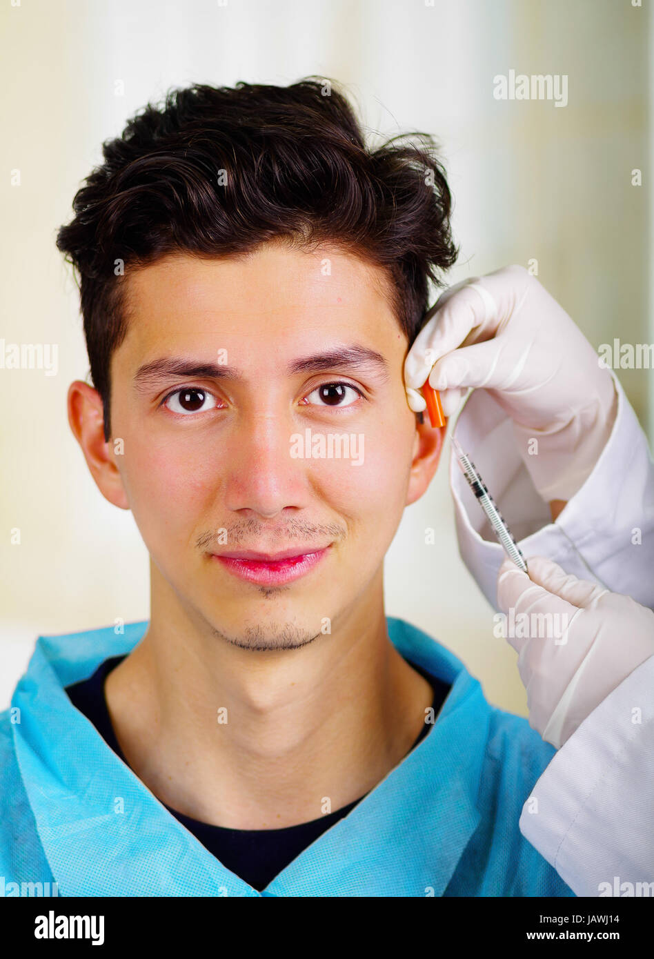 Handsome young man, receiving facial cosmetic treatment injections ...