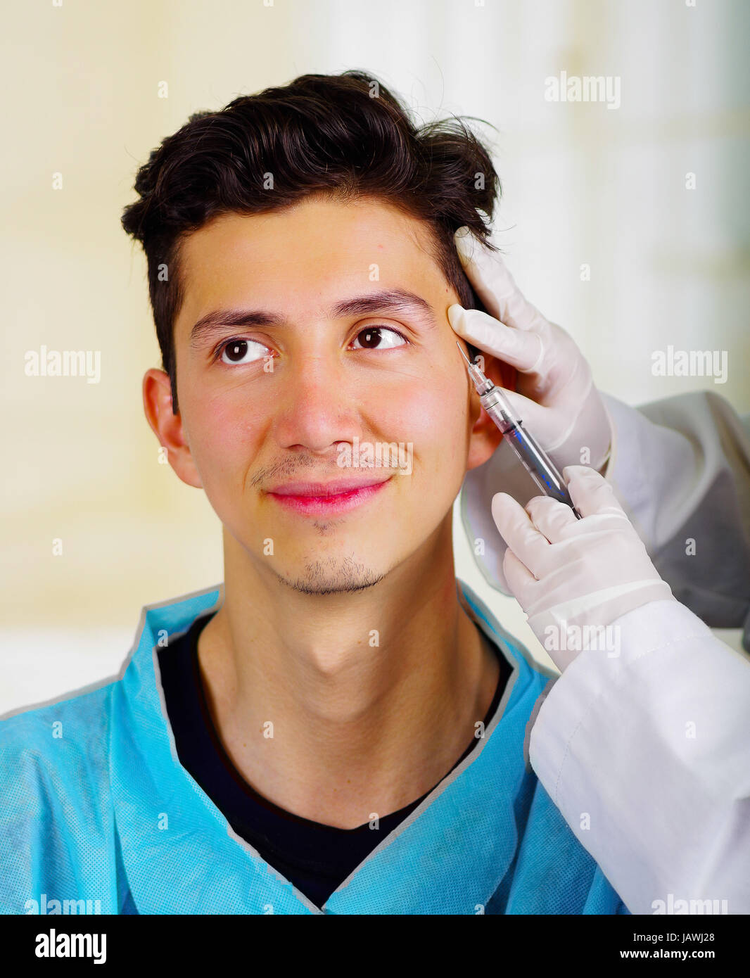 Handsome young man, receiving facial cosmetic treatment injections ...