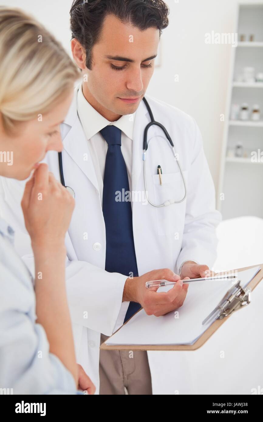 Doctor and his patient looking at clipboard together Stock Photo - Alamy