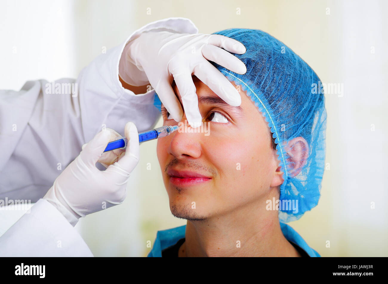 Closeup of a handsome smiling young man, receiving facial cosmetic ...