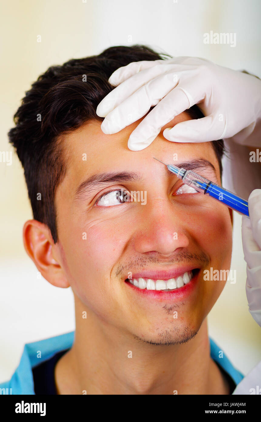 Handsome young man, receiving facial cosmetic treatment injections ...