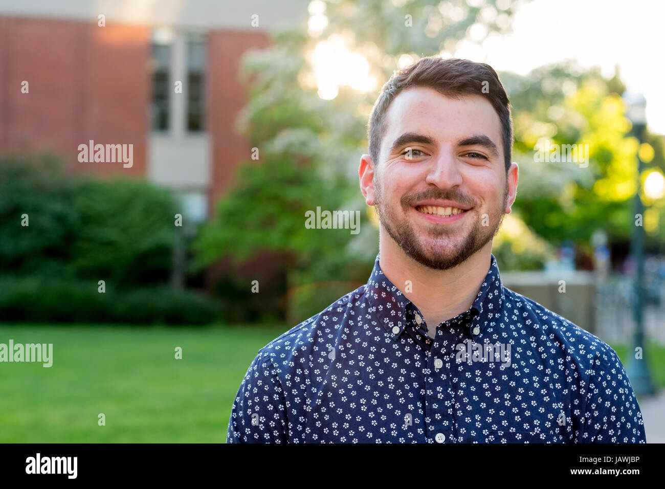 Male college senior outdoors for a natural light portrait on a ...