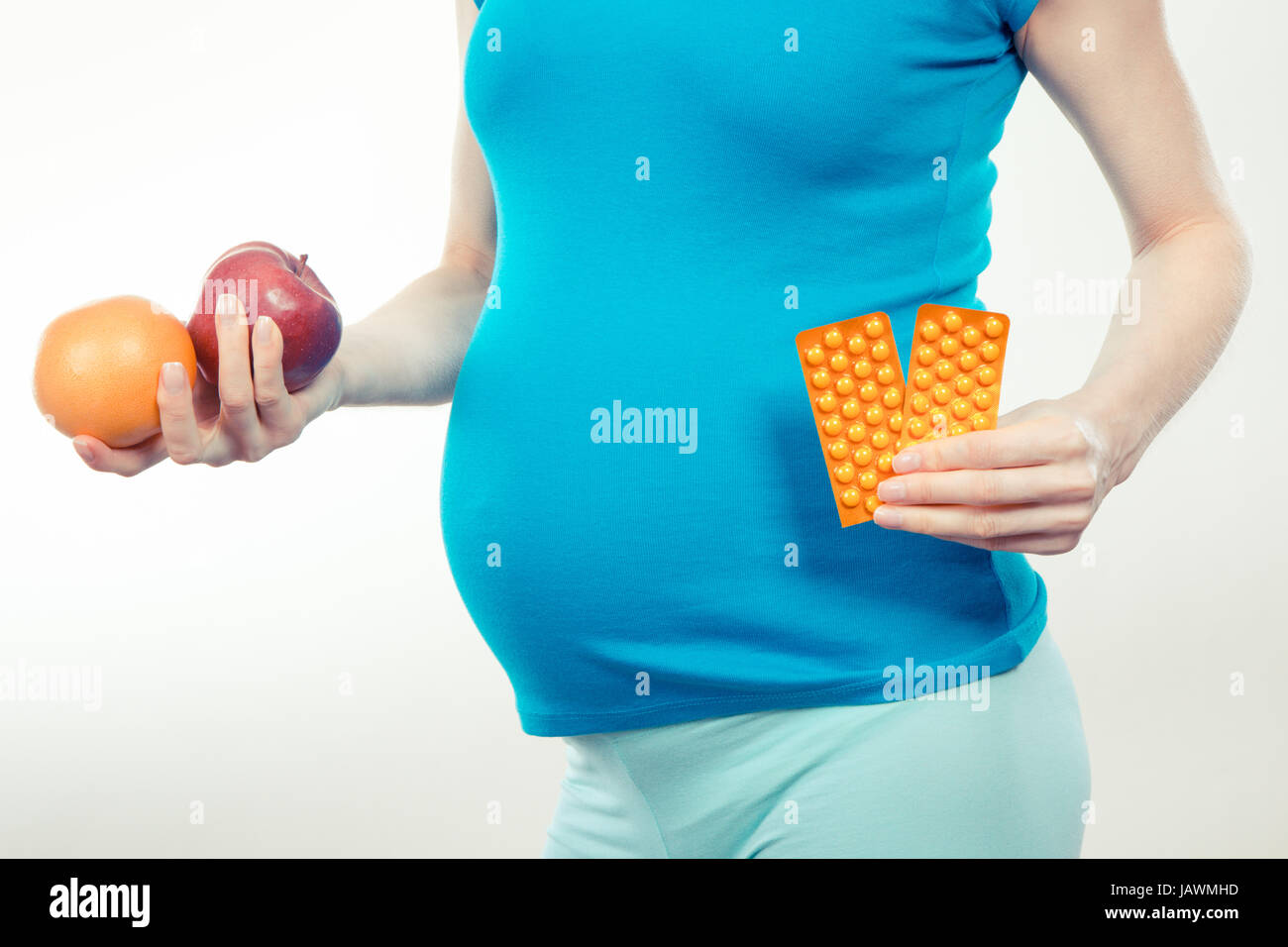 Vintage photo, Pregnant woman holding fresh fruits and medical tablets ...