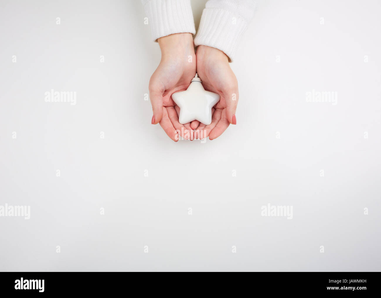 Image of decorative toy star on female hands over white background ...