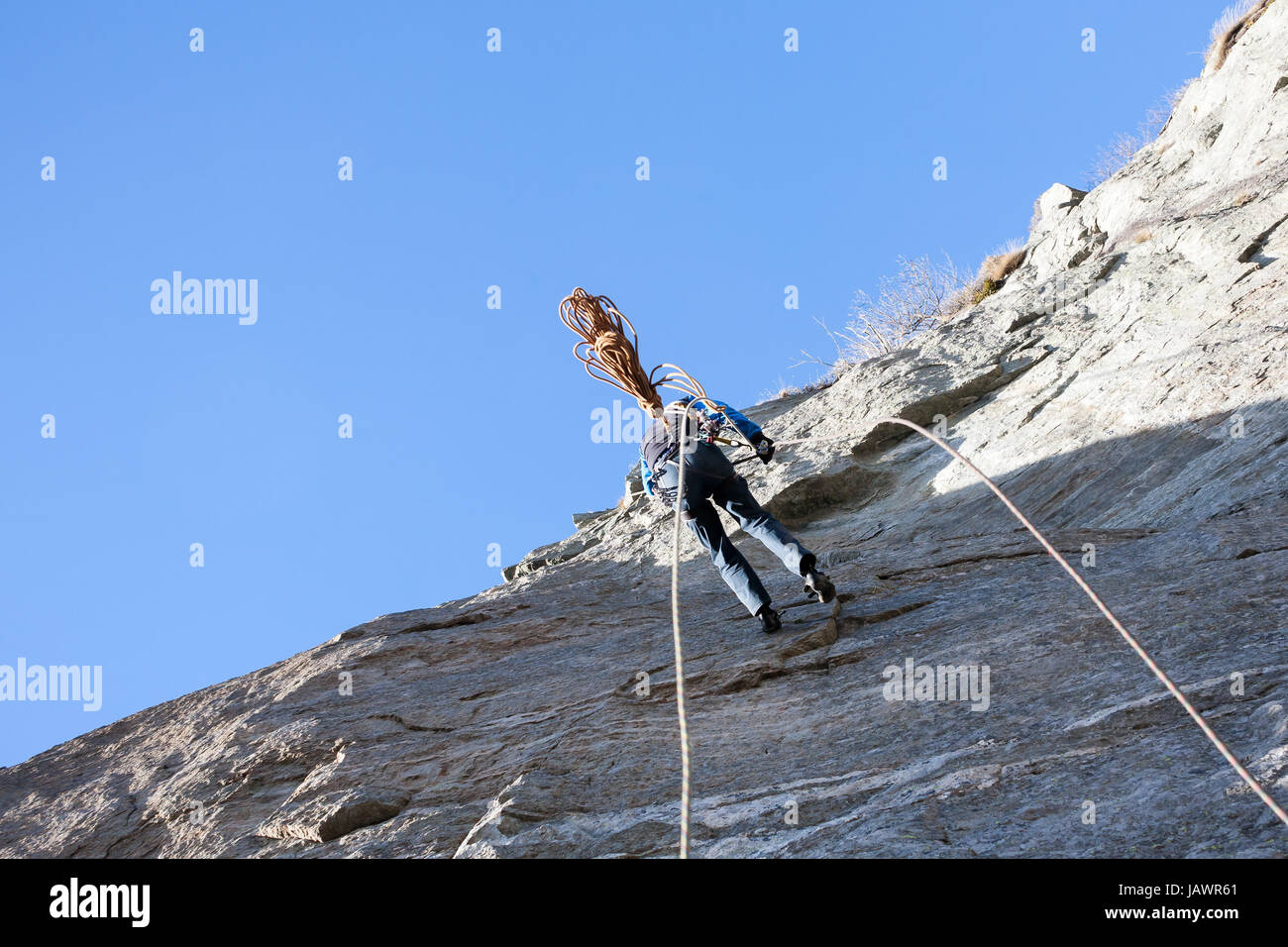 A rock climber abseiling off a climb. Italian Alps Stock Photo - Alamy