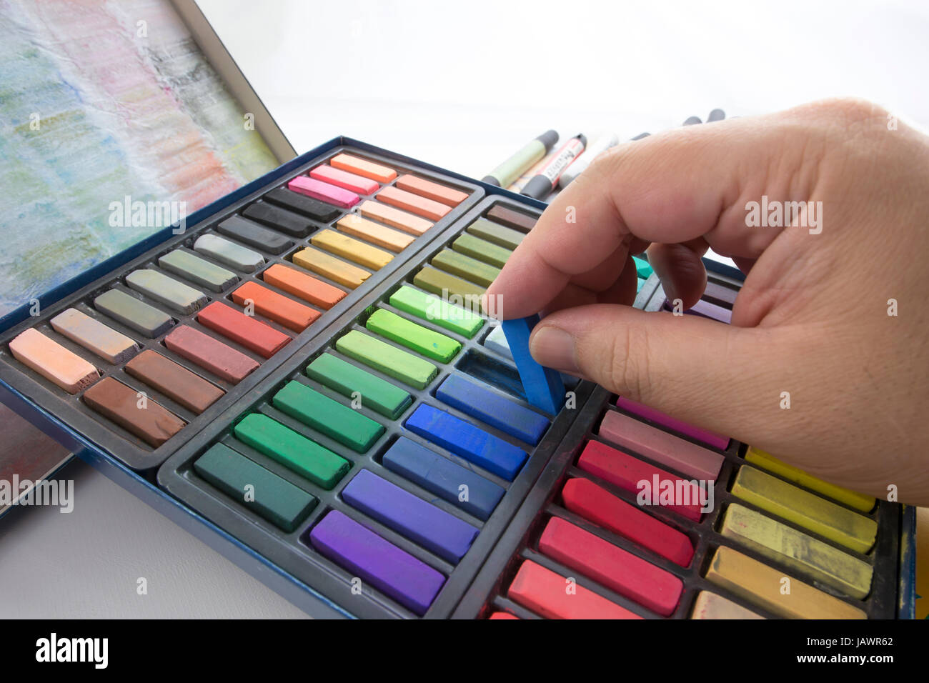 Artist hand picking a chalk to finish his art Stock Photo - Alamy