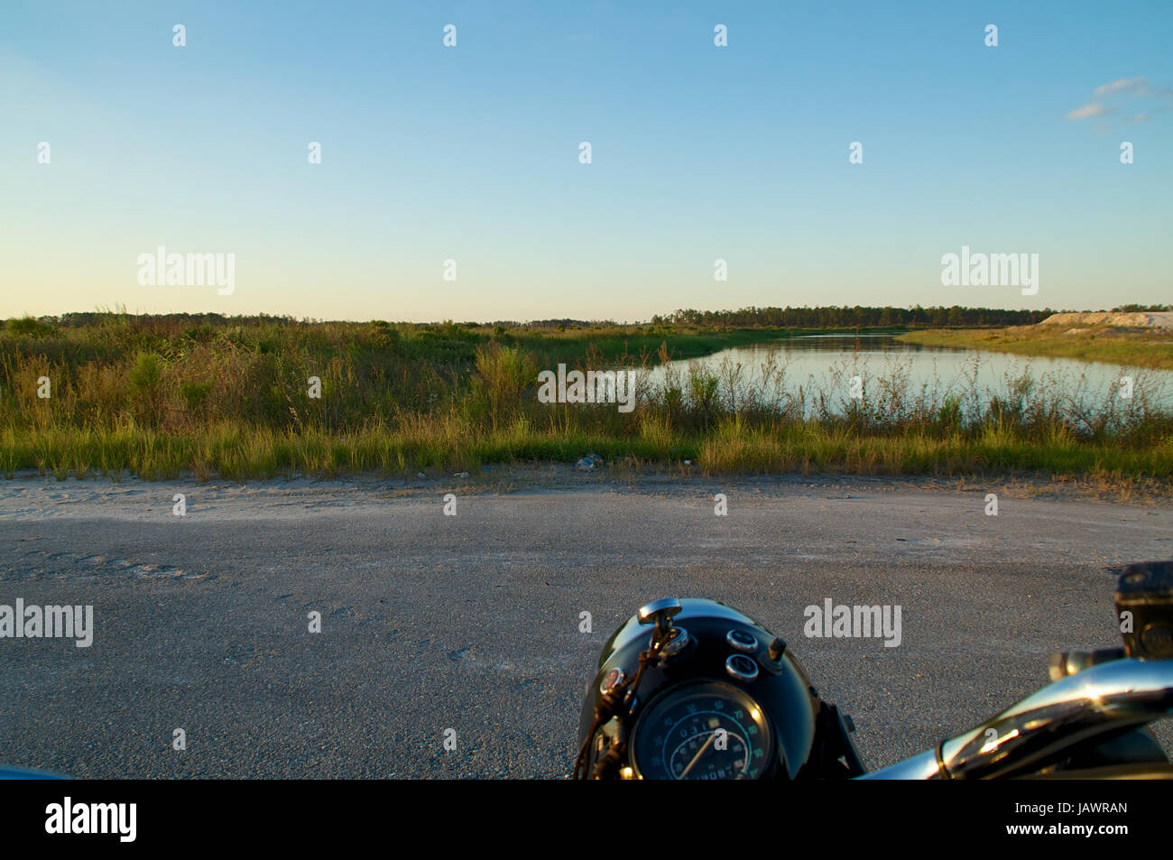 Looking over the handlebars of a vintage motorcycle at the end of the ...