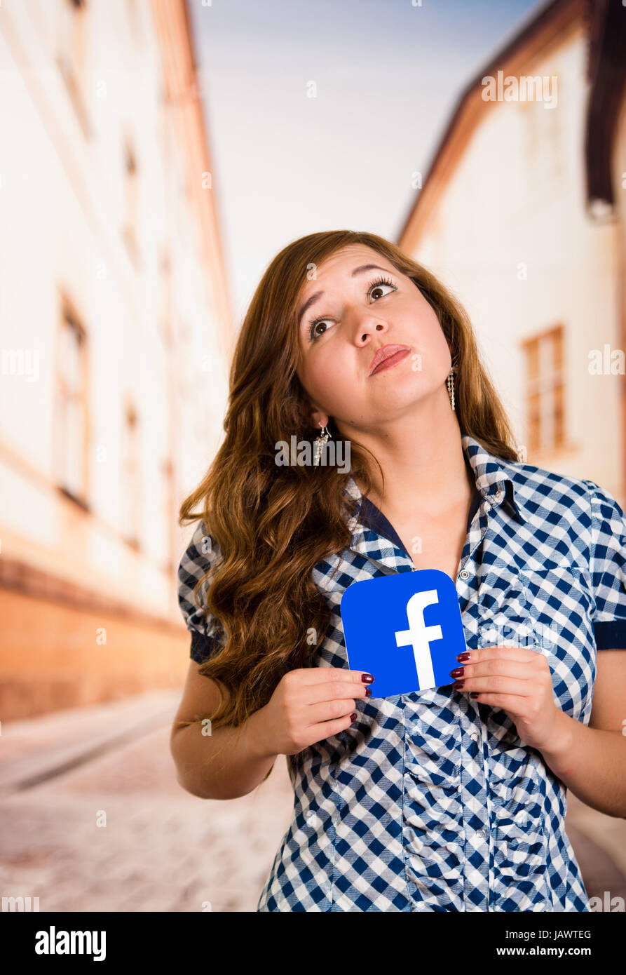 Quito, Ecuador - March 11, 2016: Woman holding a sticker facebook icon ...