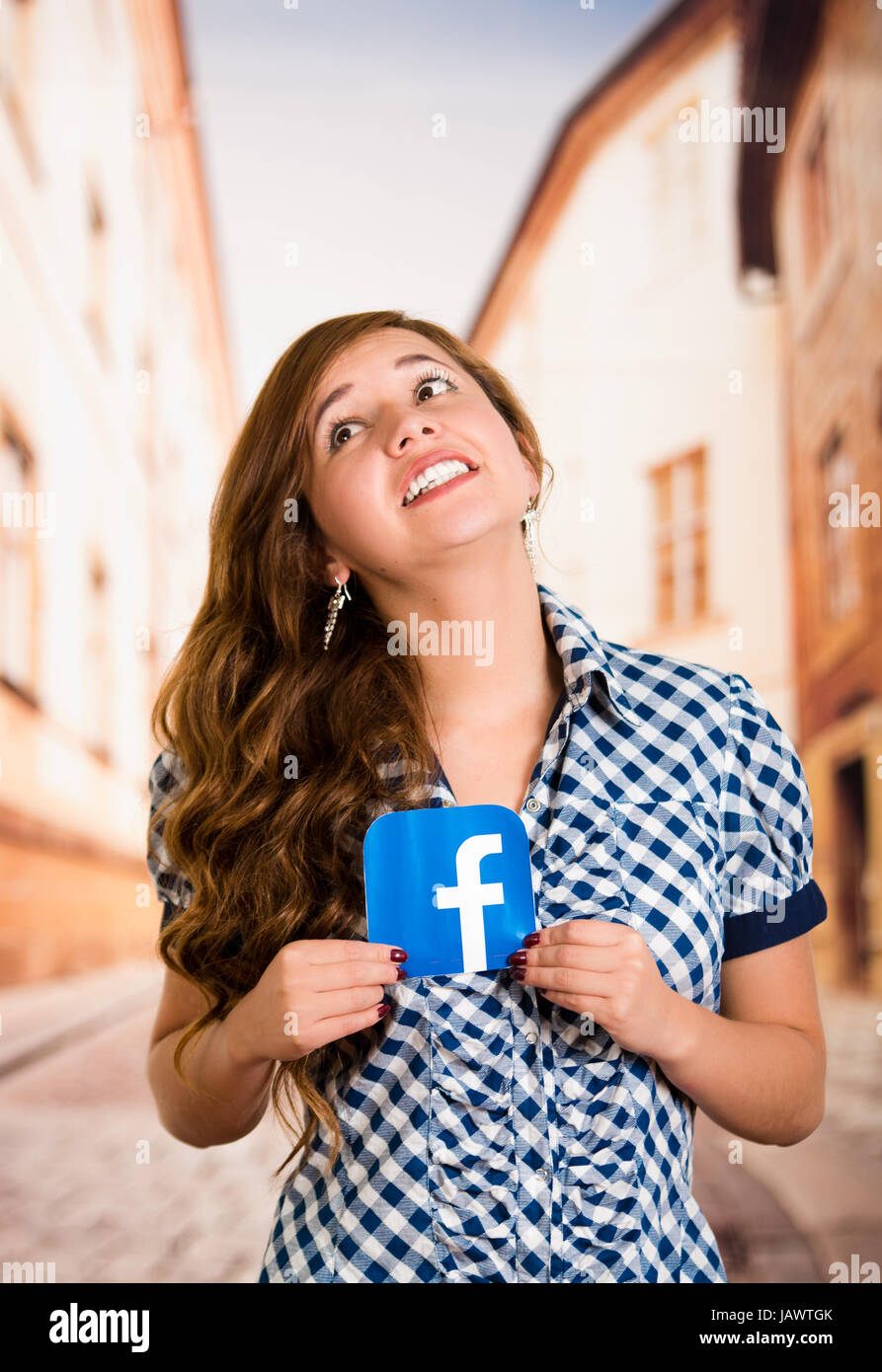 Quito, Ecuador - March 11, 2016: Woman holding a sticker facebook icon ...