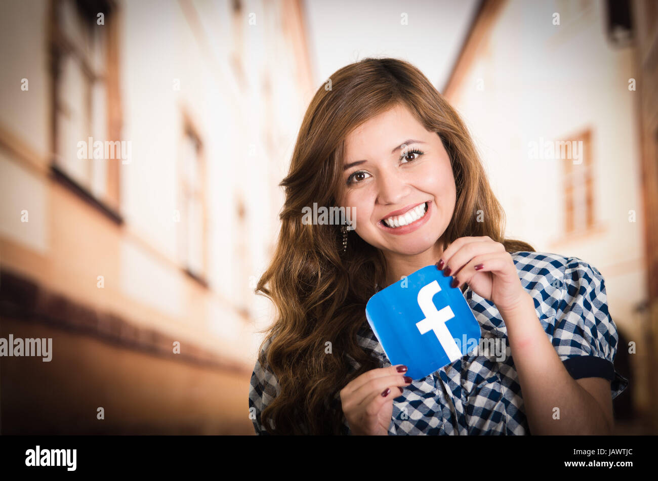 Quito, Ecuador - March 11, 2016: Woman holding a sticker facebook icon ...