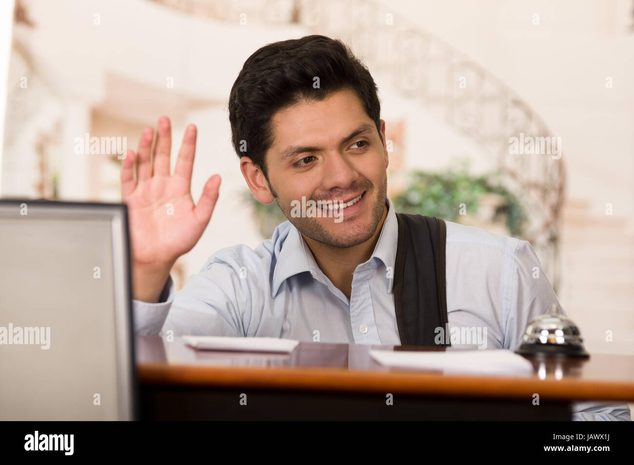 Happy guest touching the bell of the recepcionist Stock Photo - Alamy
