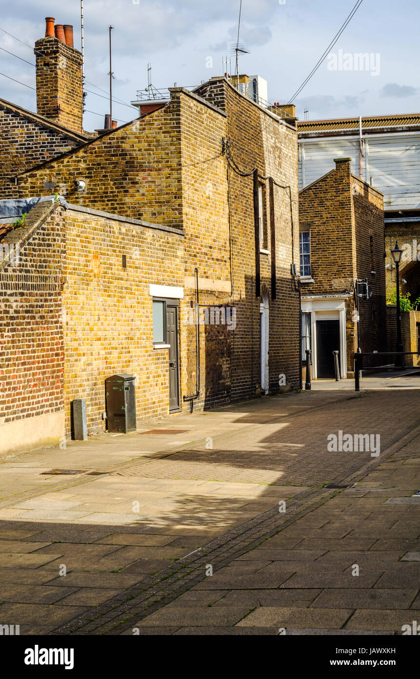 Typical old English buildings, low brick buildings across a narrow ...