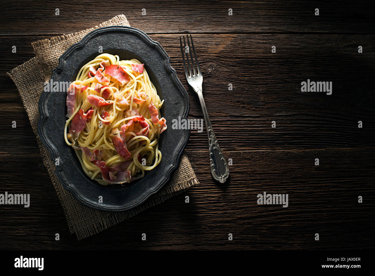 Fresh spaghetti wit prosciutto on wooden table overhead shoot Stock ...