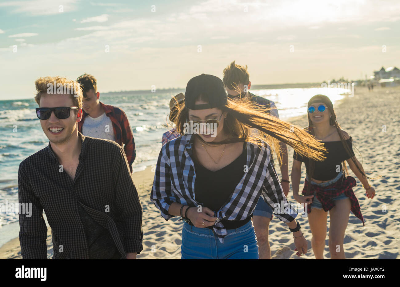Group of hipster young friends running along beach together Stock Photo ...