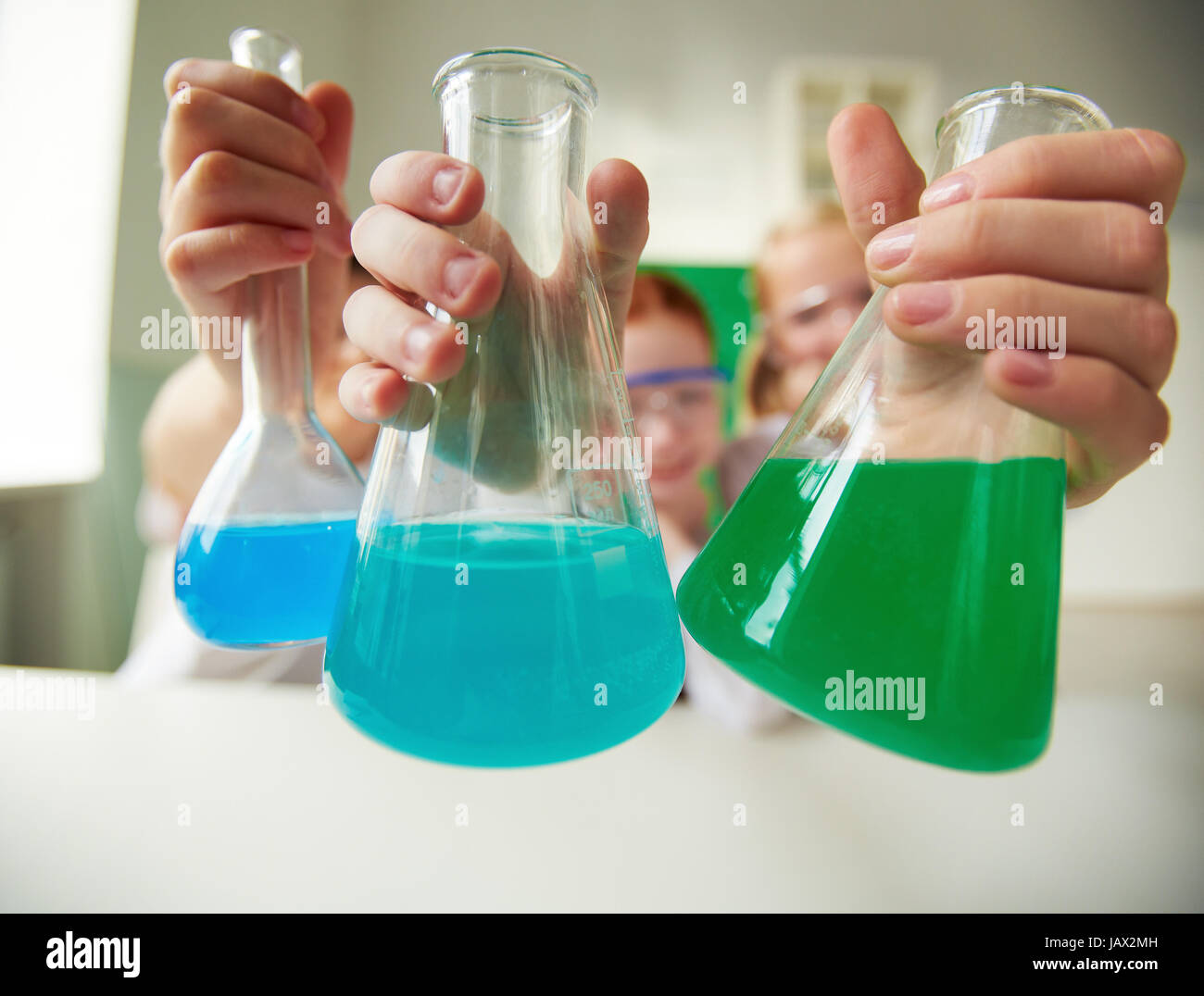 Three tubes with chemical liquids held by schoolchildren Stock Photo ...
