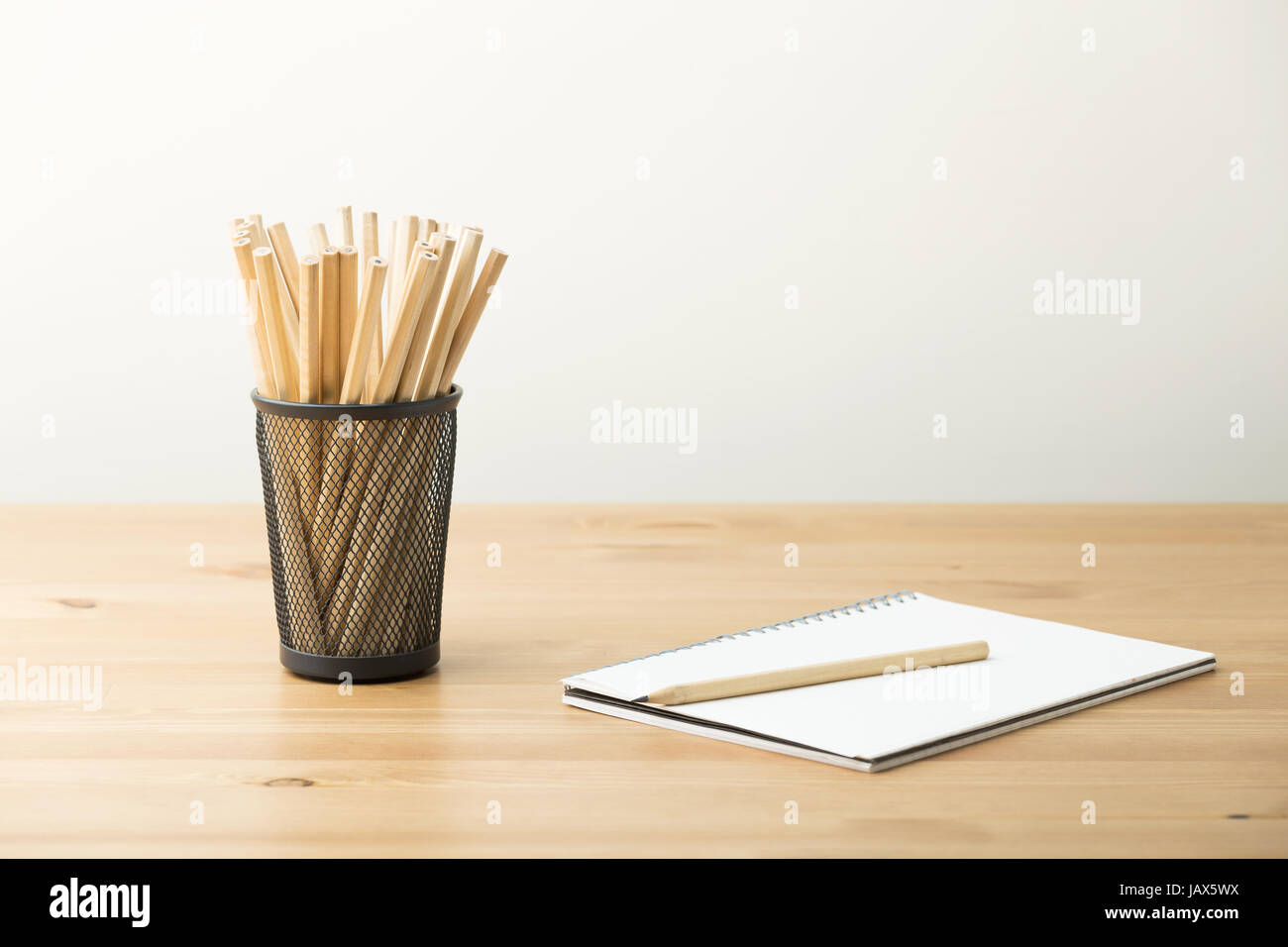 Pencil in pot with notebook Stock Photo - Alamy