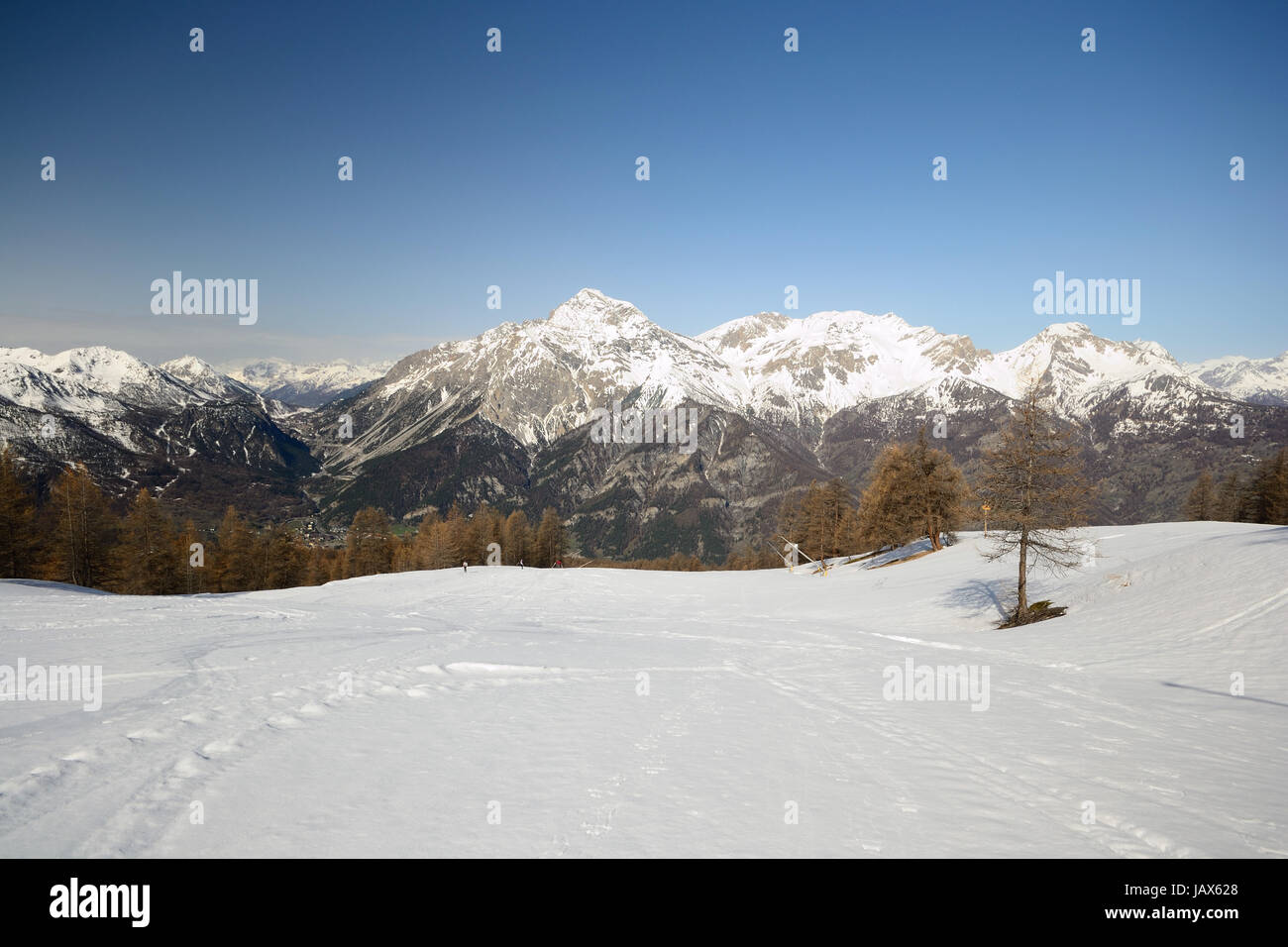 Ski resort and snowy slope in scenic background of high mountain peak ...