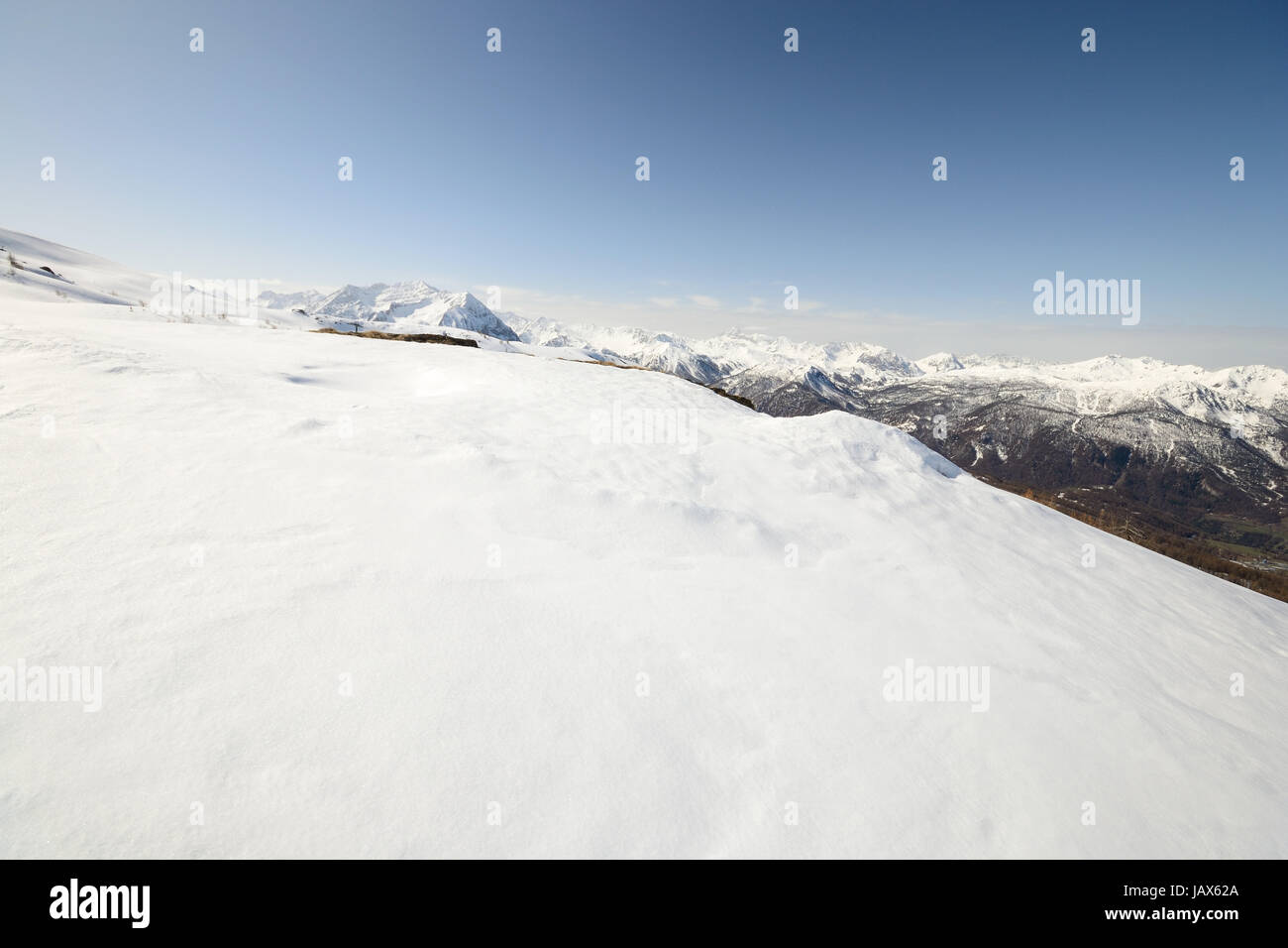 Ski resort and snowy slope in scenic background of high mountain peak ...