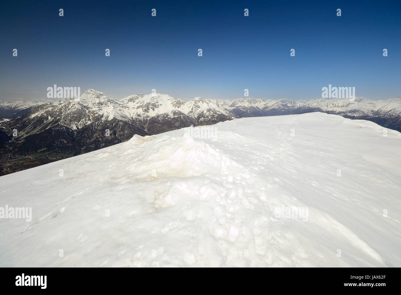 Ski resort and snowy slope in scenic background of high mountain peak ...