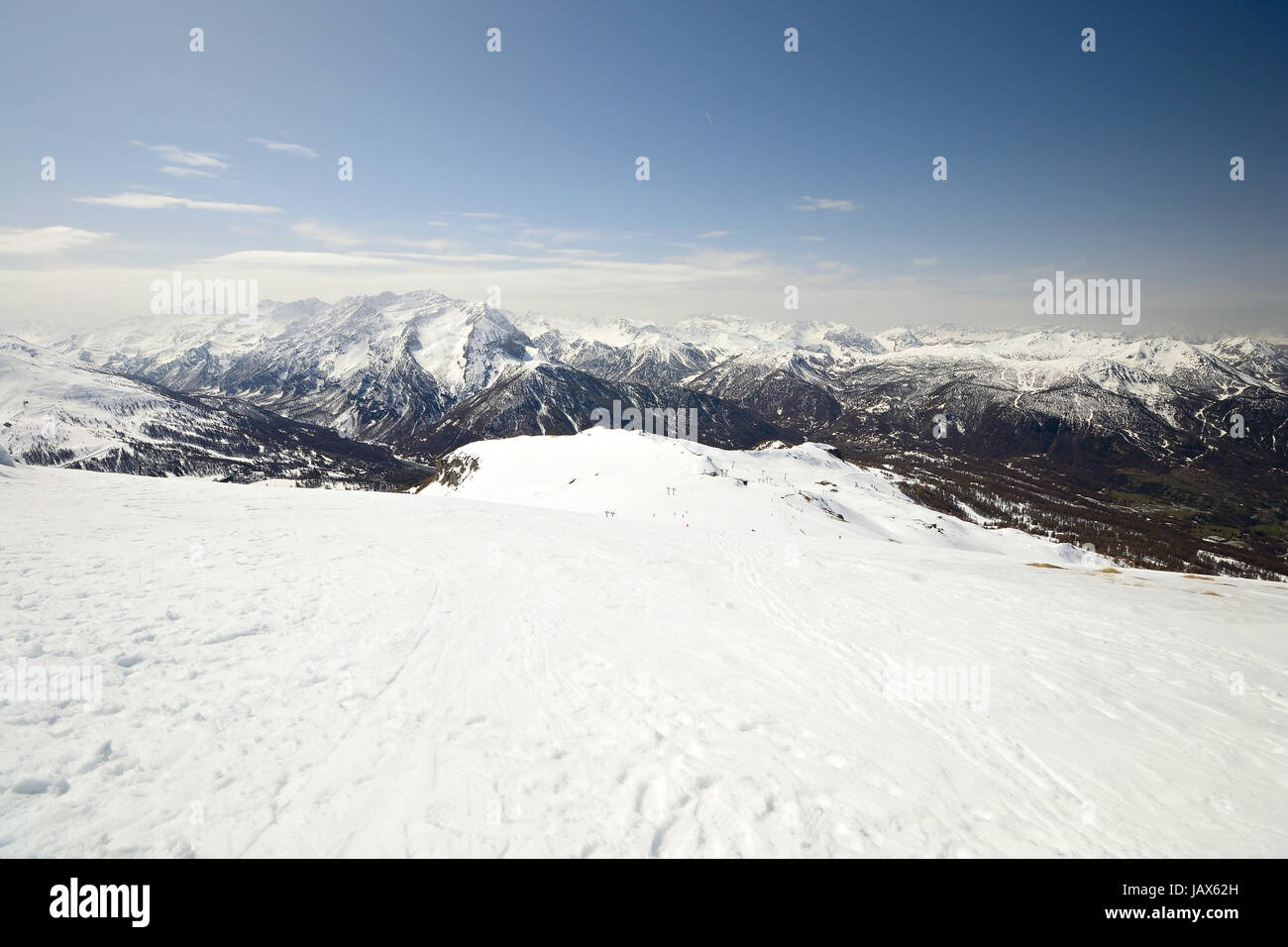 Ski resort and snowy slope in scenic background of high mountain peak ...