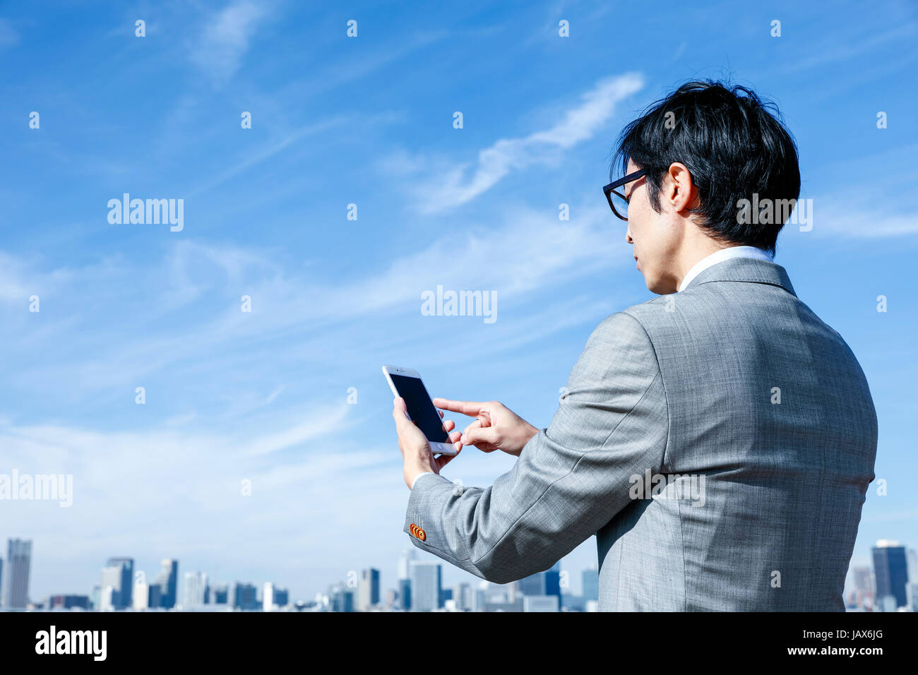Japanese businessman with smartphone downtown Tokyo, Japan Stock Photo ...