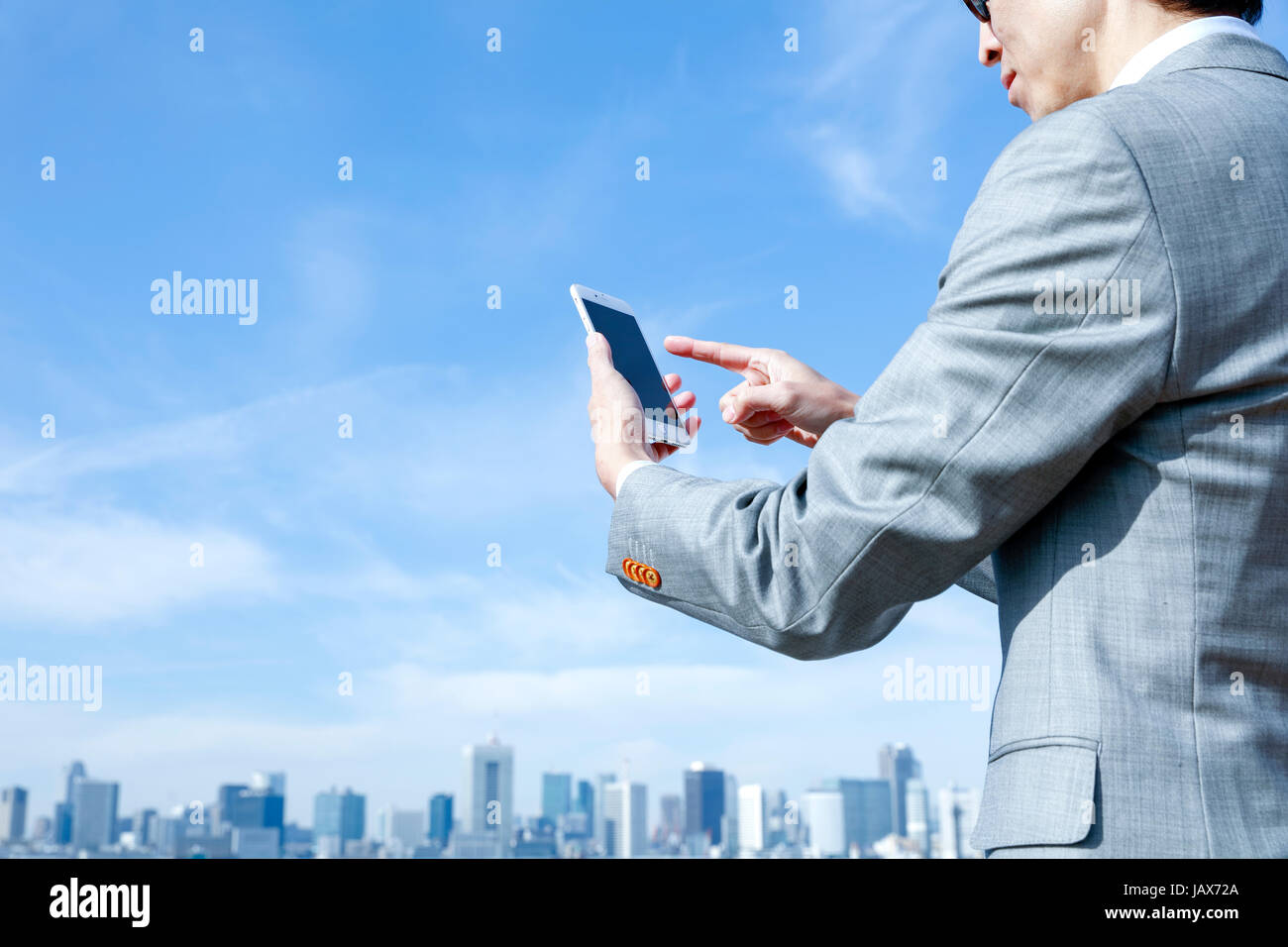 Japanese businessman with smartphone downtown Tokyo, Japan Stock Photo ...