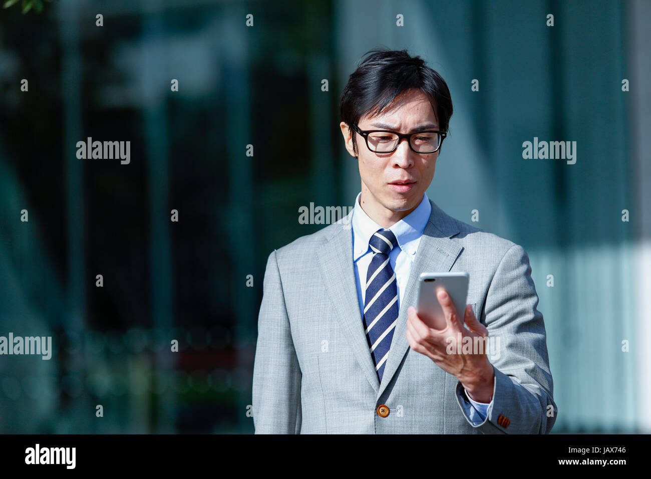 Japanese businessman with smartphone downtown Tokyo, Japan Stock Photo ...