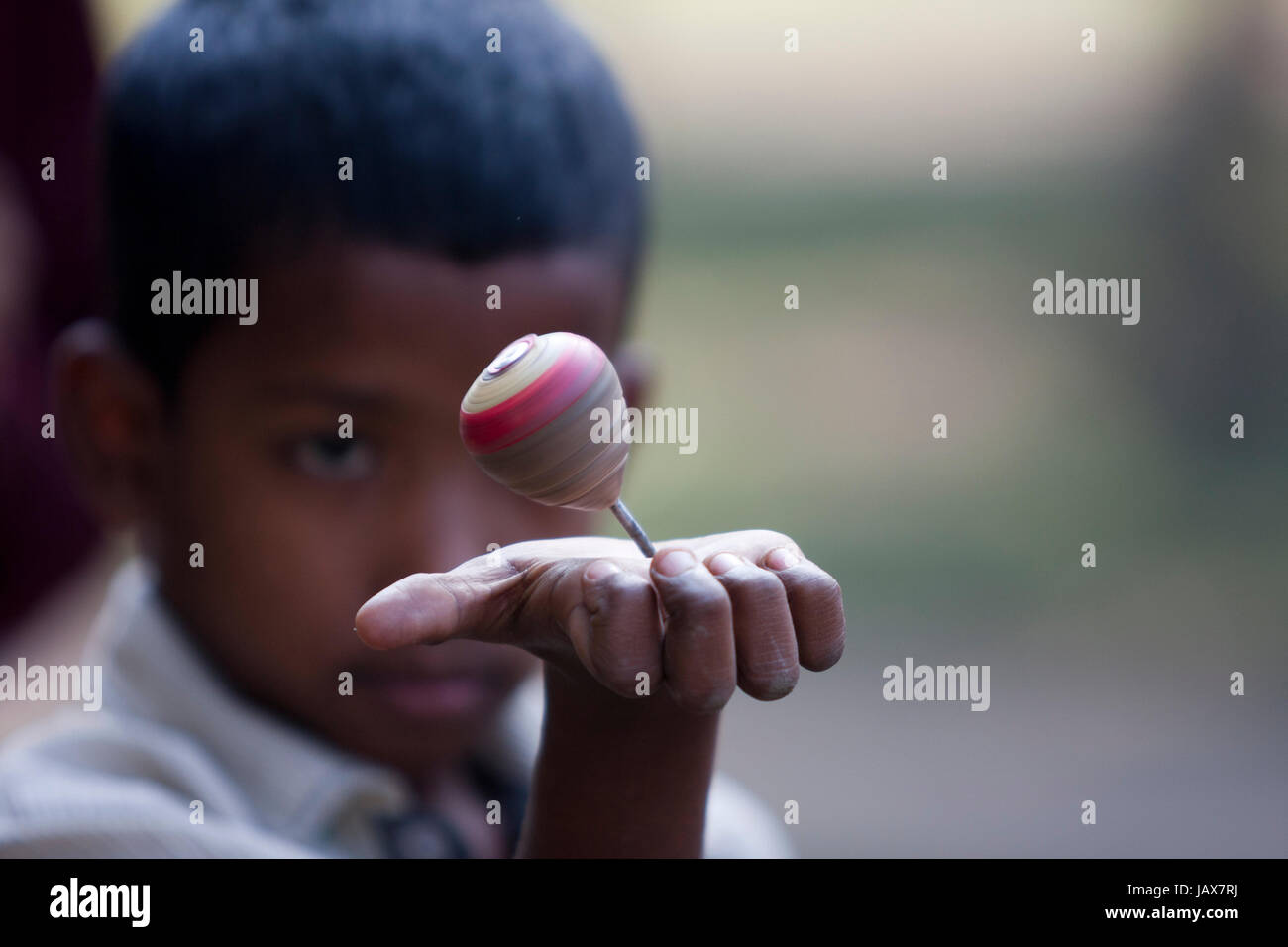 A child plays with a traditional top locally known as lattu or latim ...