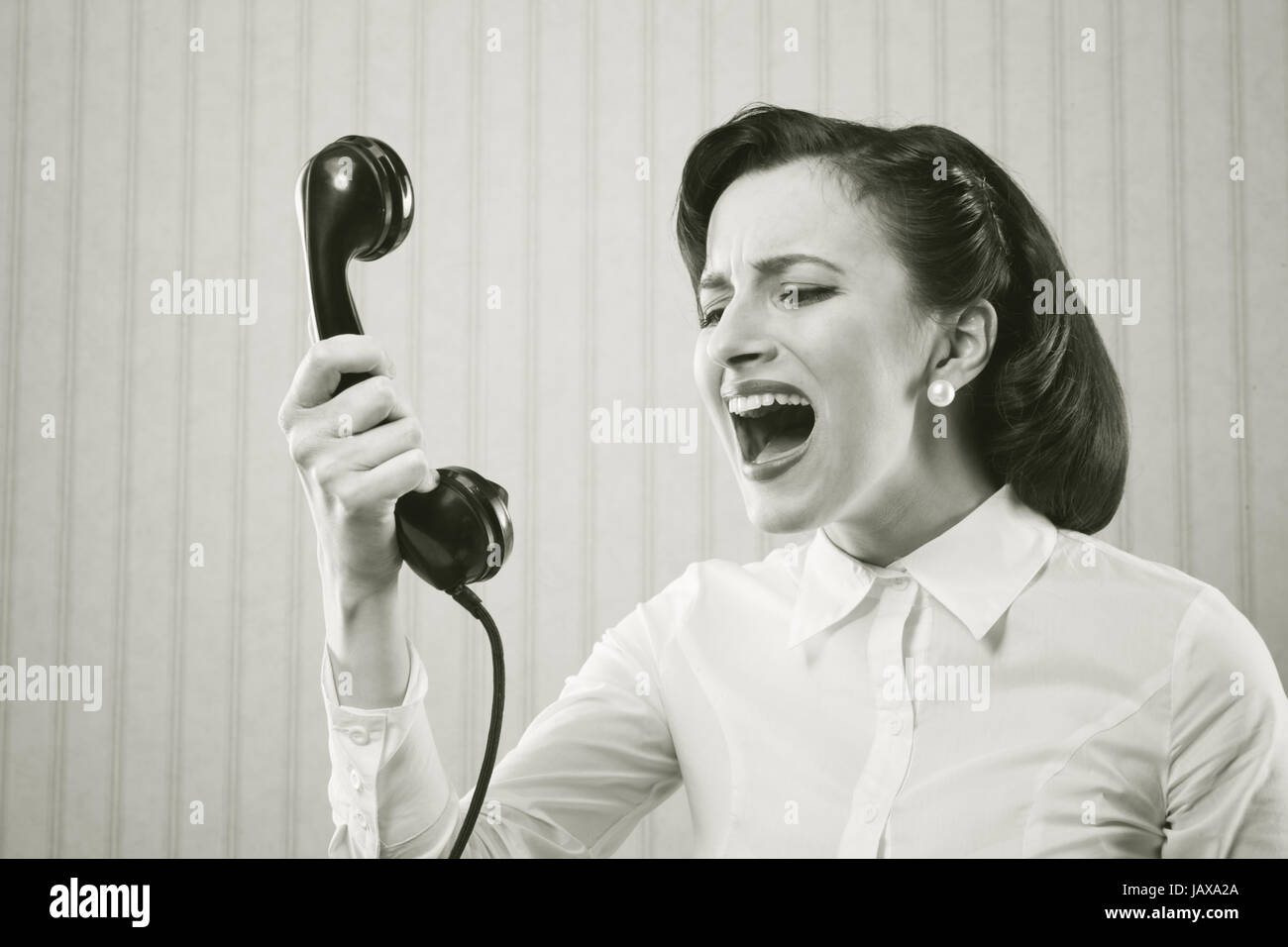Young Woman shouting into telephone Stock Photo - Alamy