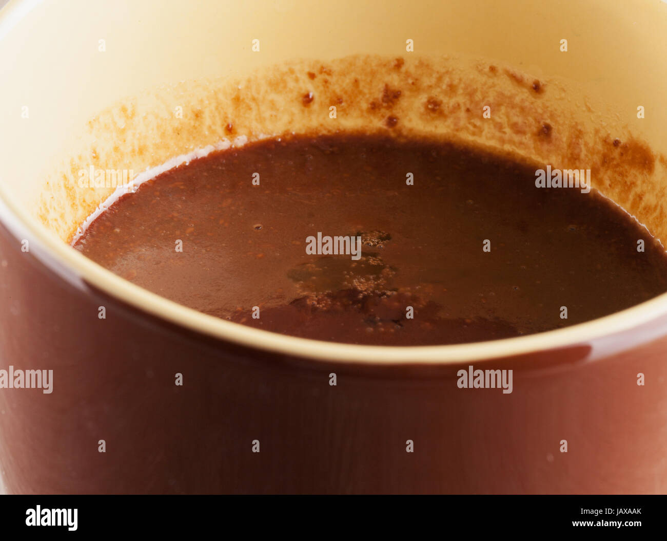 Boiling liquid chocolate in a yellow and brown cup Stock Photo - Alamy