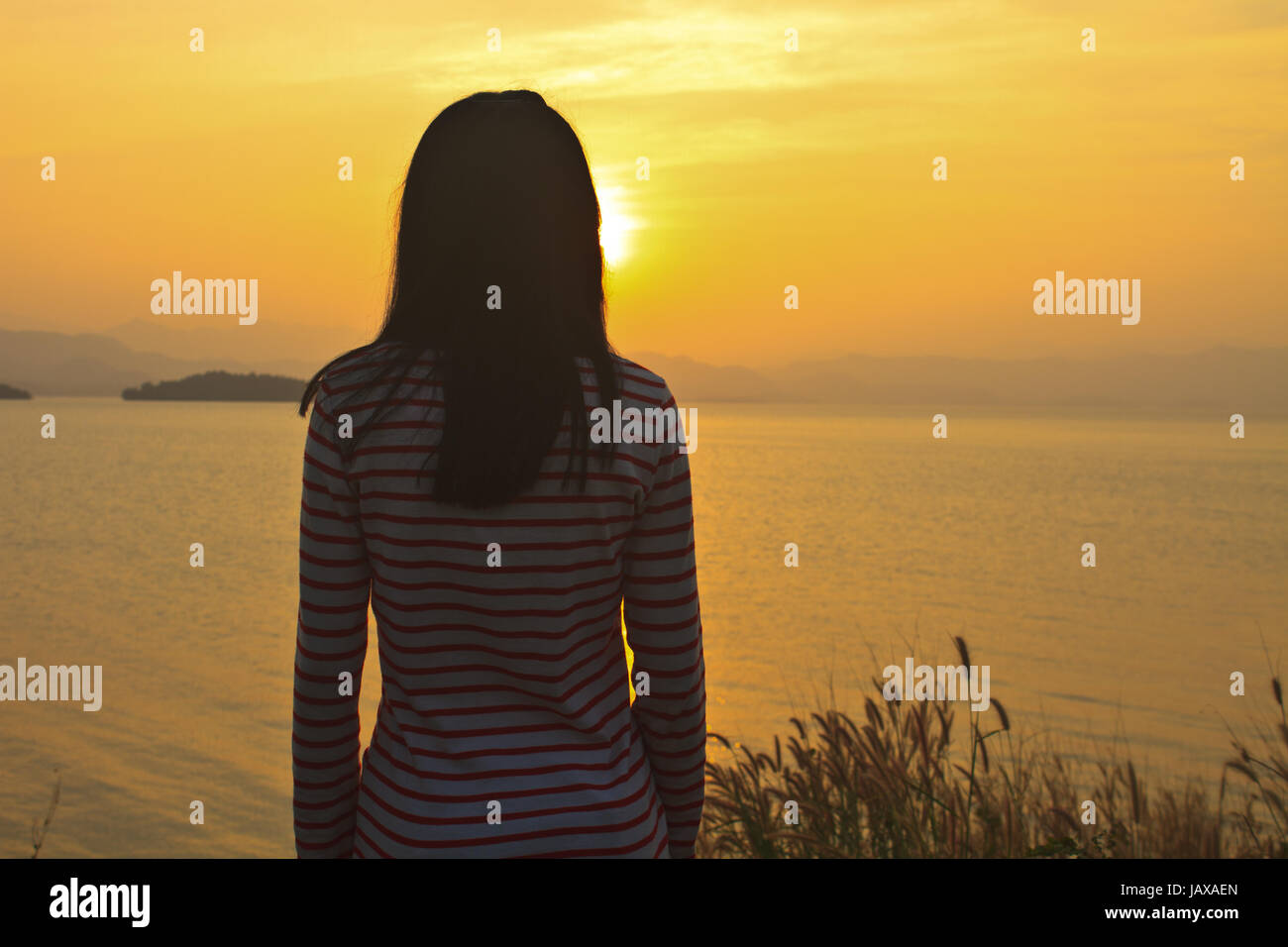 young girl sitting and have a relax under sunset scene Stock Photo - Alamy