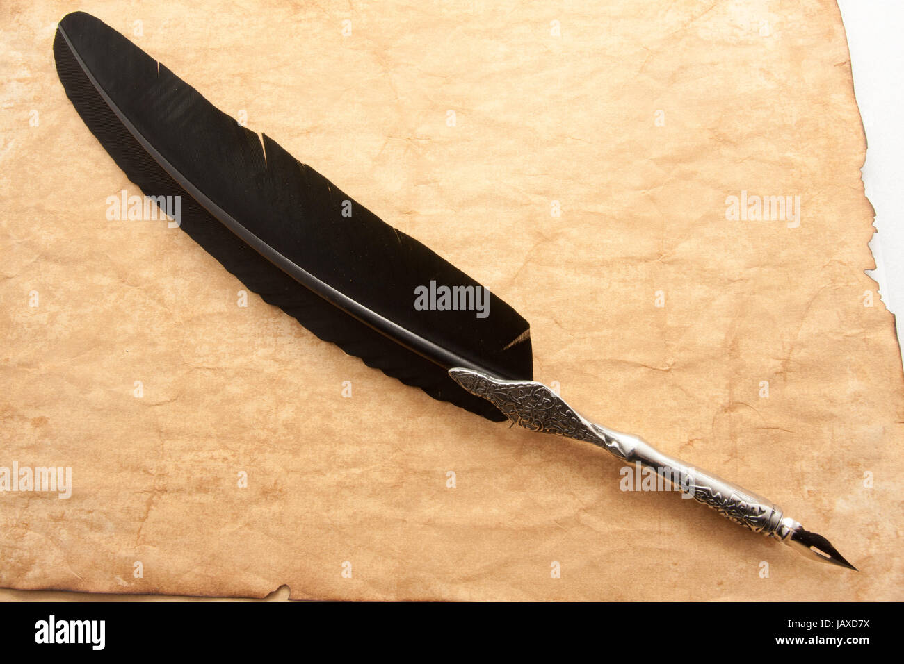 Feather pen and ink bottle on old paper background Stock Photo - Alamy