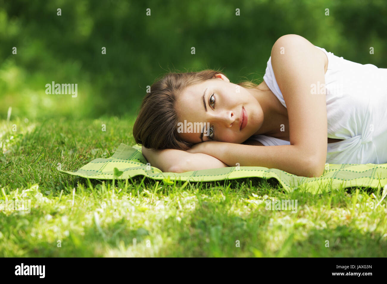 Young beautiful woman laying on the grass Stock Photo - Alamy