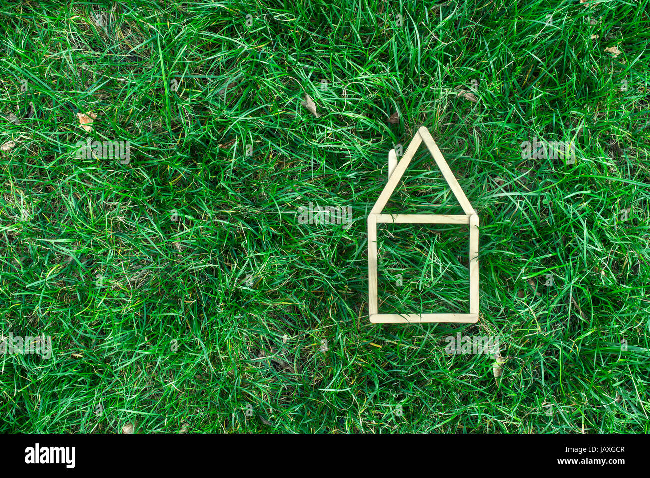 Model house made of wooden sticks on green grass Stock Photo - Alamy