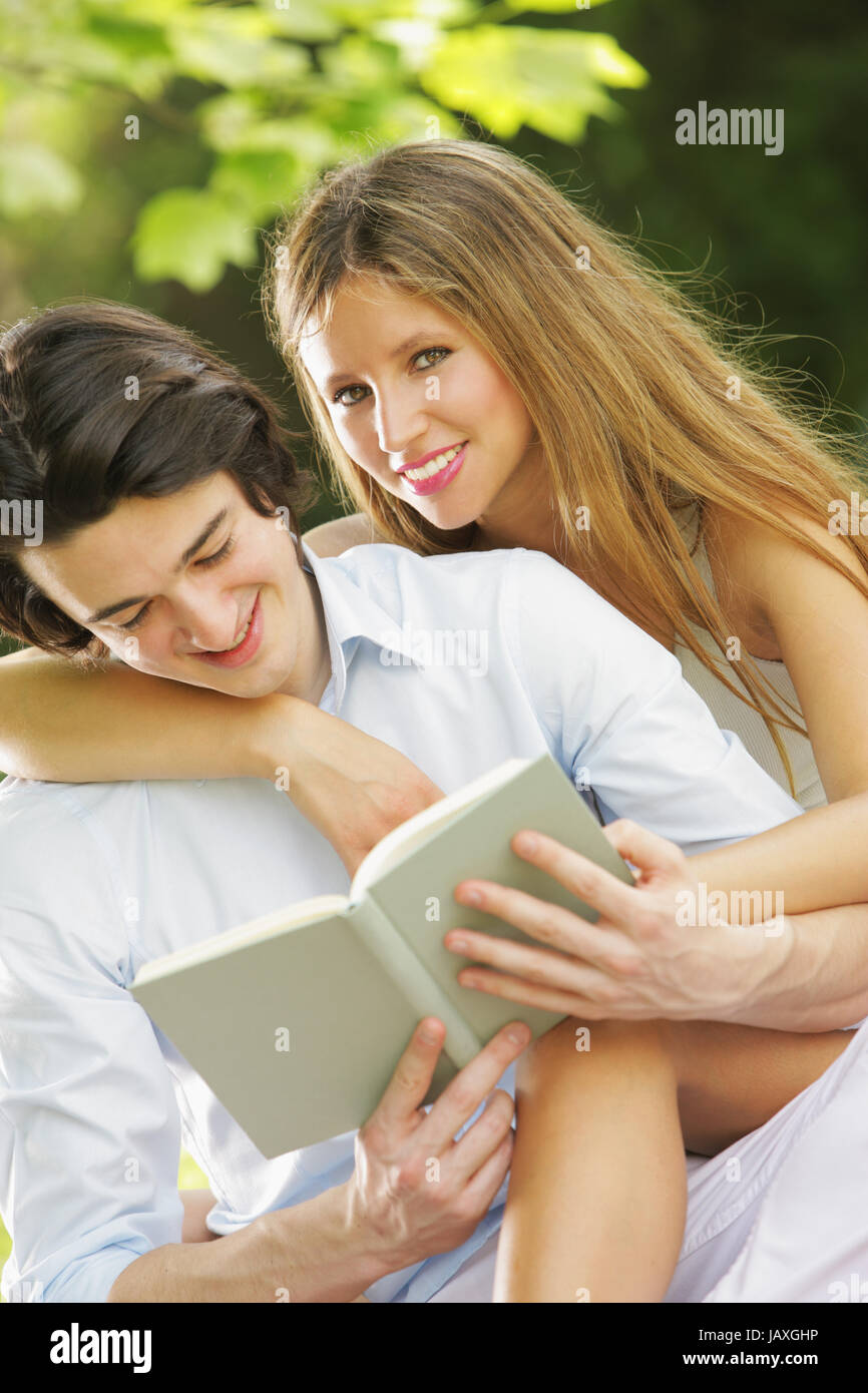 a young couple read a book together in the park. close up Stock Photo ...