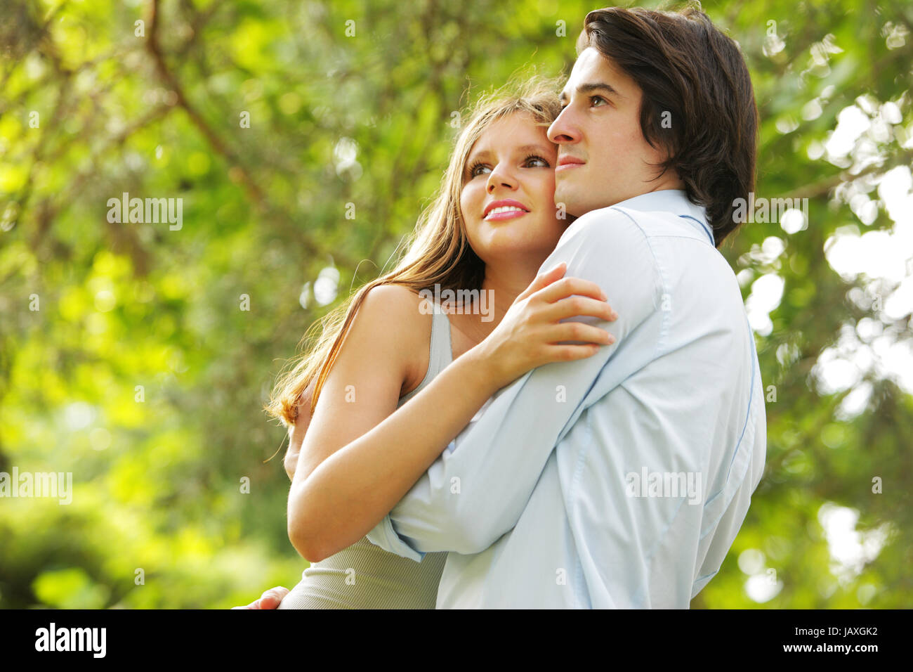 a romantic couple in the park watching the horizon, imagining the ...