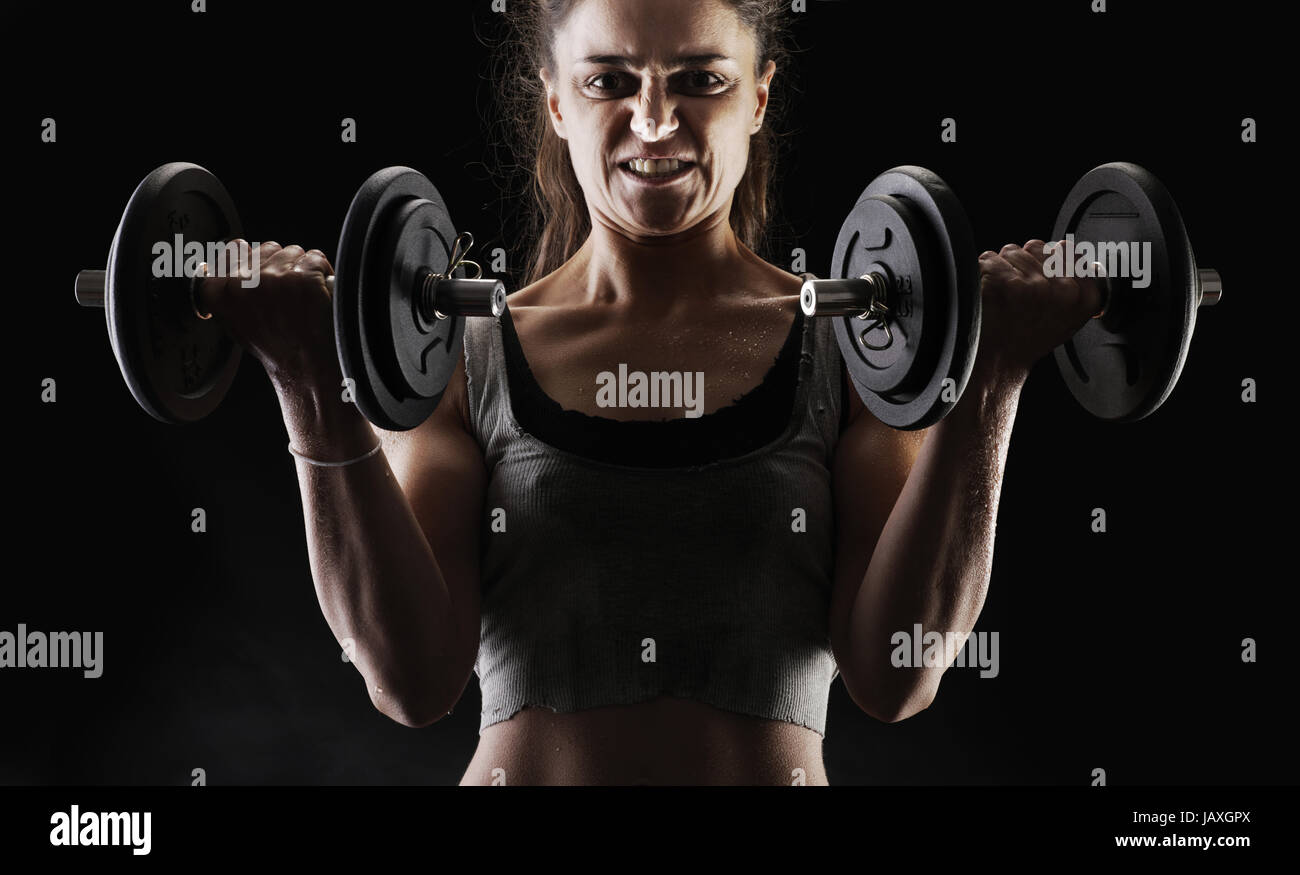 Young woman lifting the dumbbells Stock Photo - Alamy