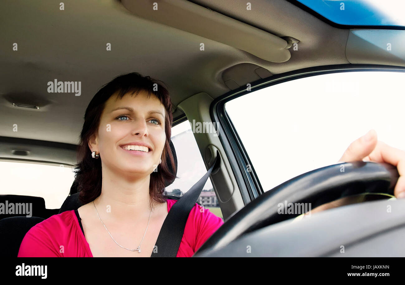 front view of smiling brunette woman driving car Stock Photo - Alamy