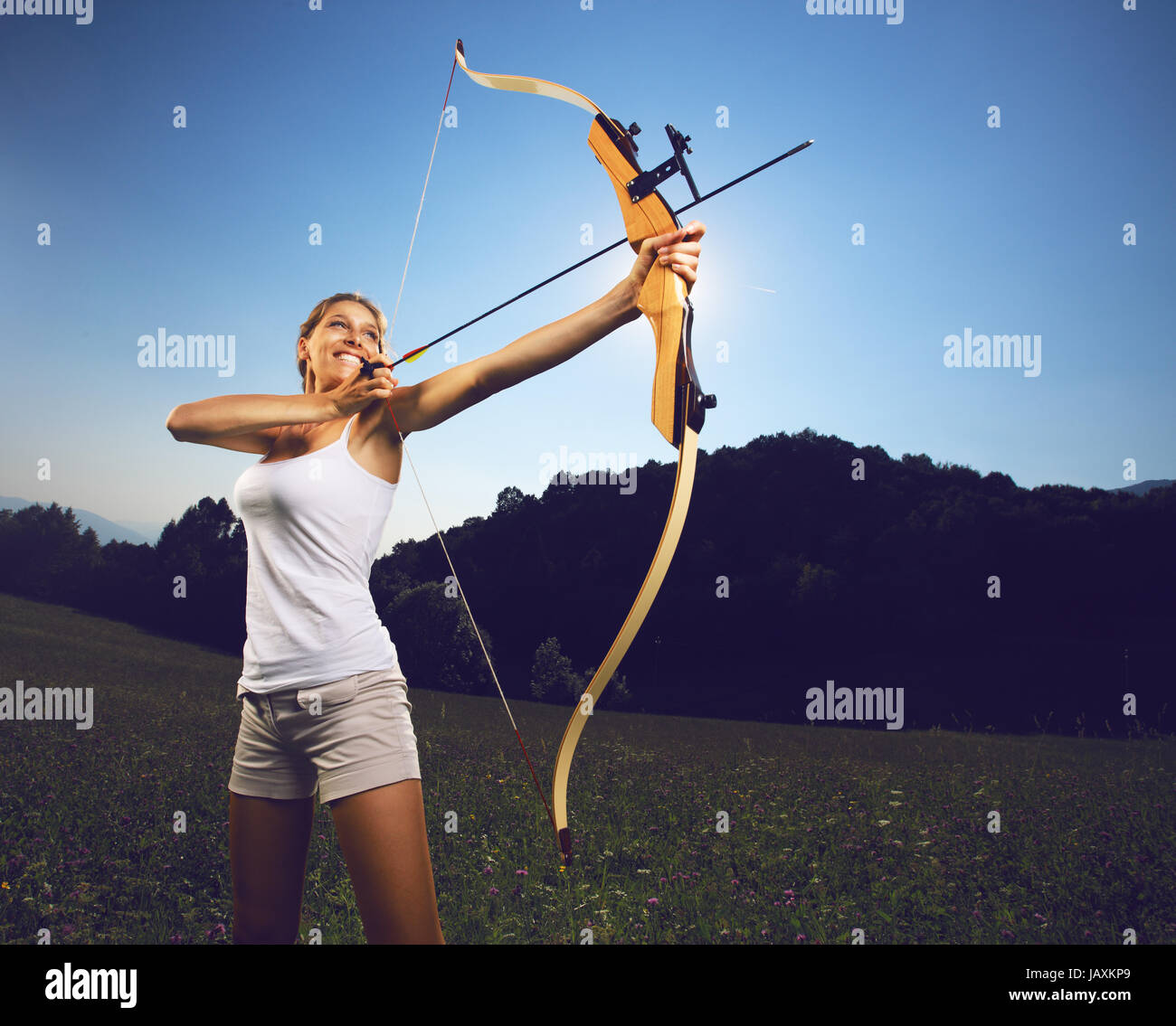 Attractive female archer bending a bow and aiming in the sky Stock ...
