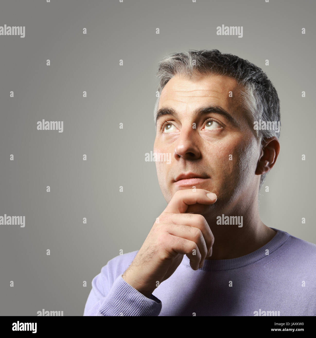 Portrait of casual man thinking and looking up Stock Photo - Alamy
