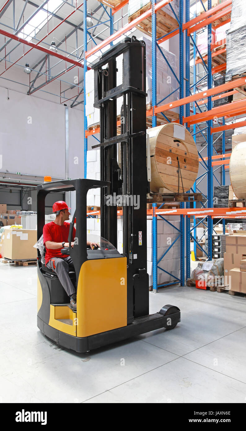 Forklift loading pallet with roll in distribution warehouse Stock Photo ...
