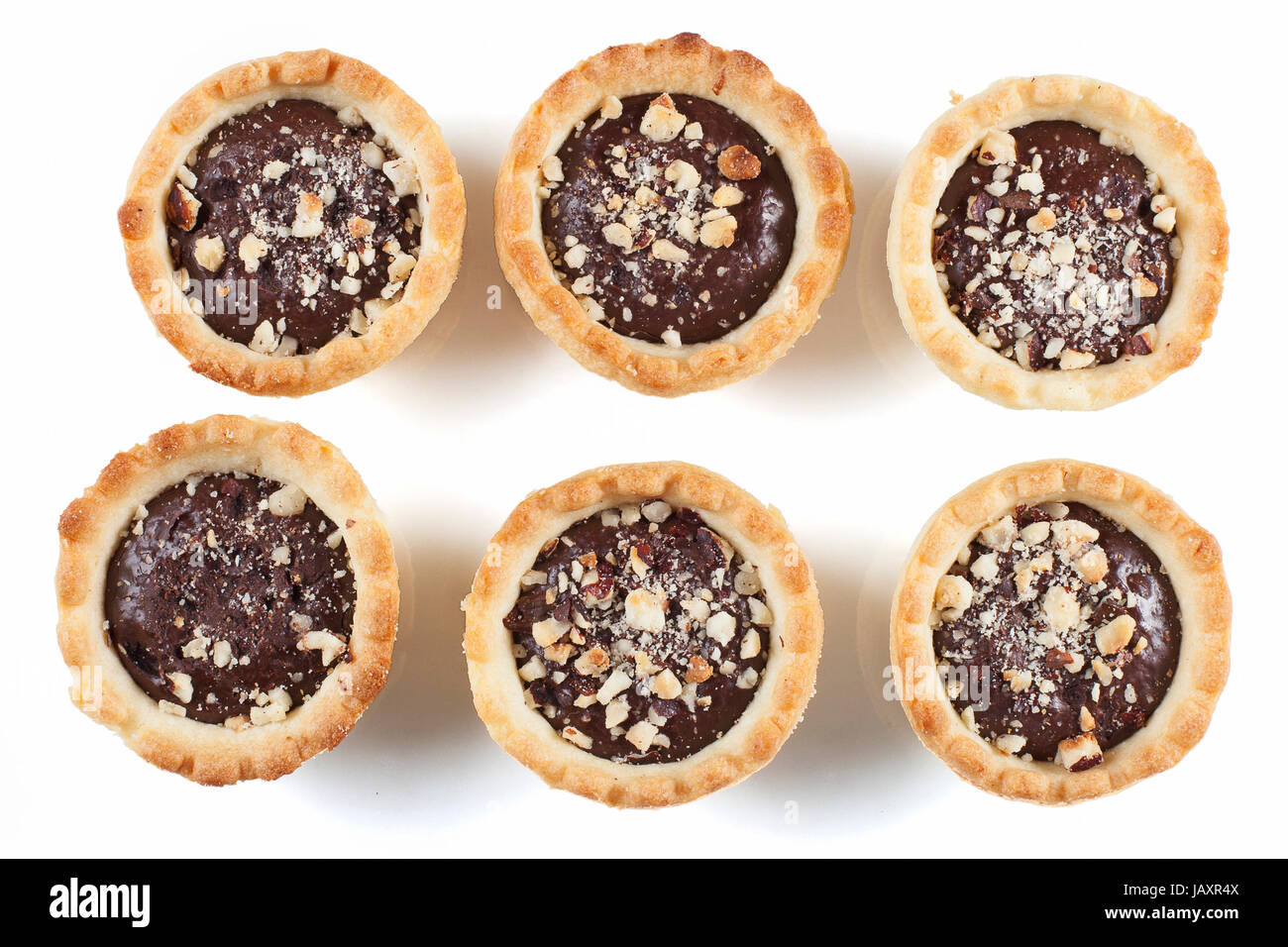 Six bite sized chocolate tarts with chopped nuts Stock Photo - Alamy