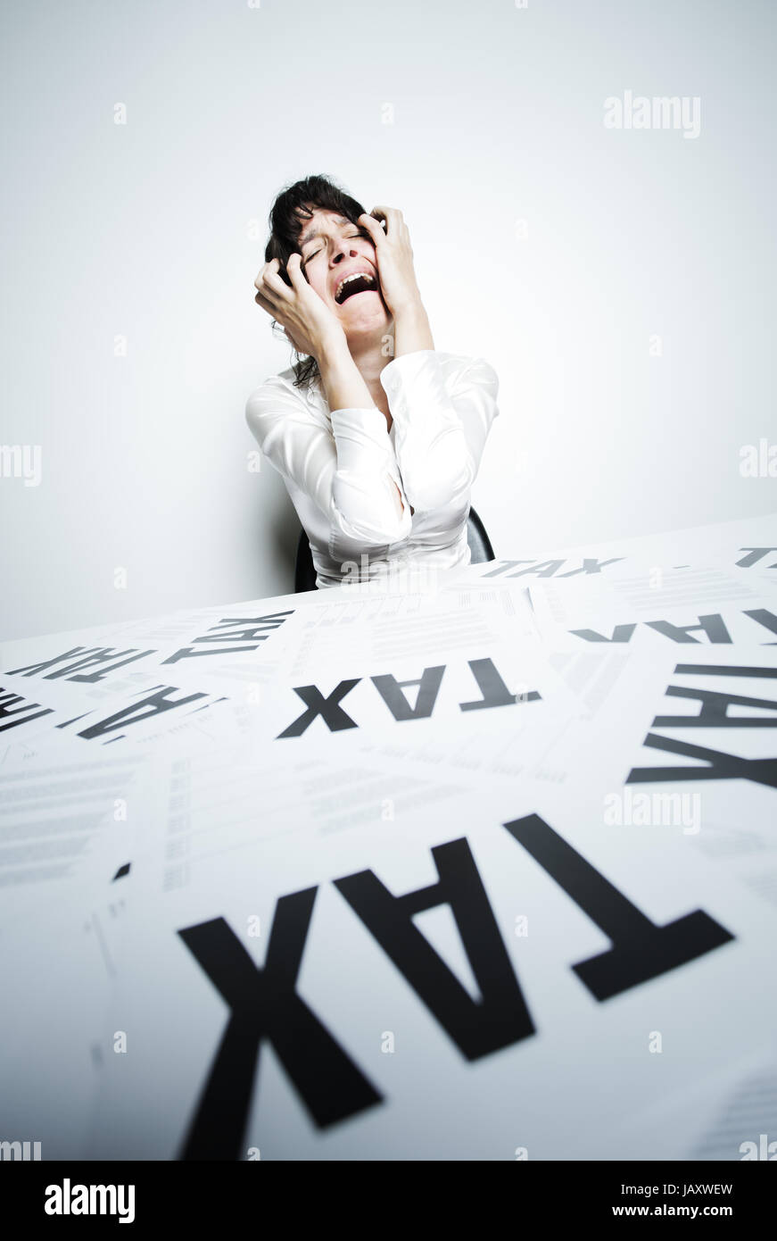 Desperate woman at her taxes-paperwork covered desk to crying bitter ...
