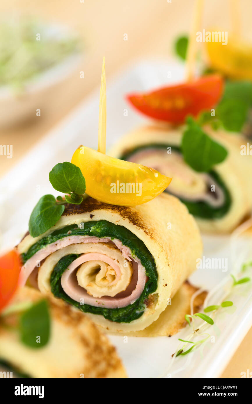 Crepe rolls as finger food filled with spinach and ham garnished with ...