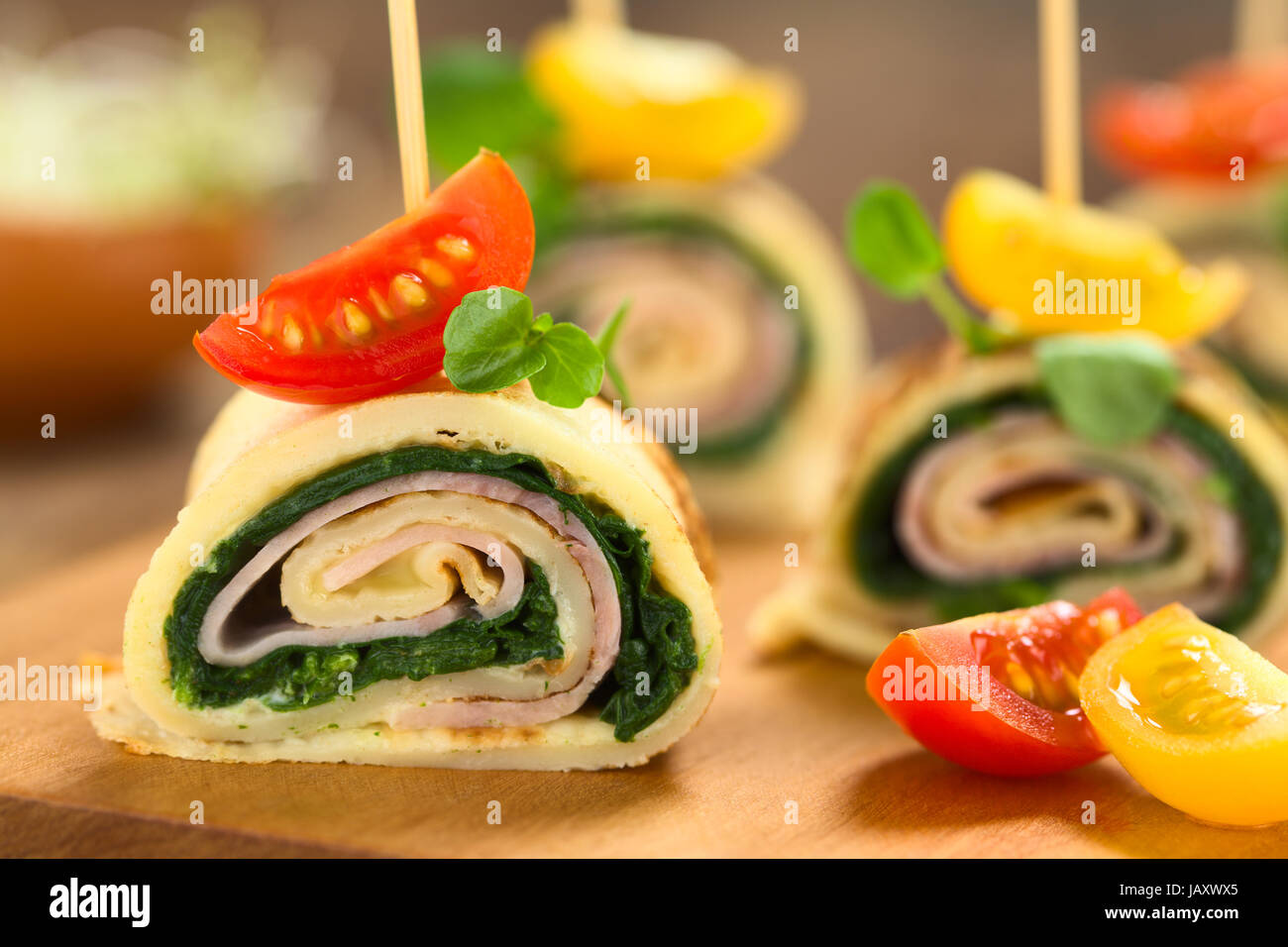 Crepe rolls as finger food filled with spinach and ham garnished with ...